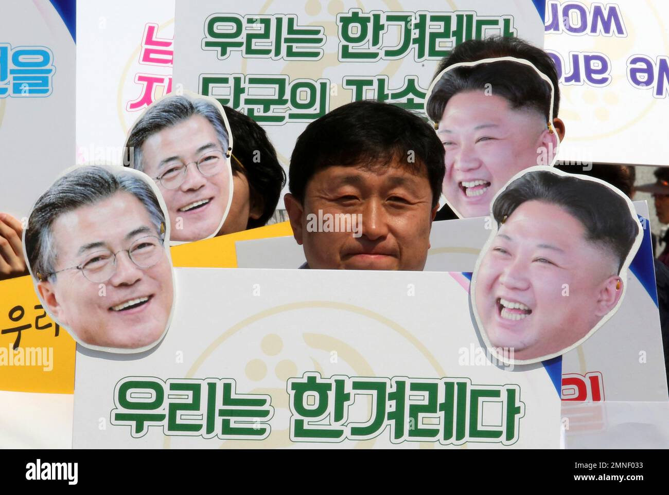 An activist with cutouts of South Korean President Moon Jae-in, left ...