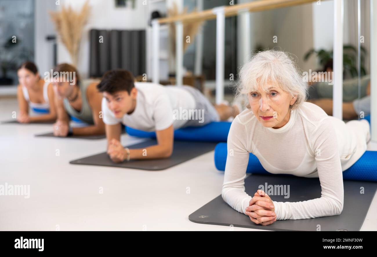 Group of different people doing exercises with roller Stock Photo - Alamy