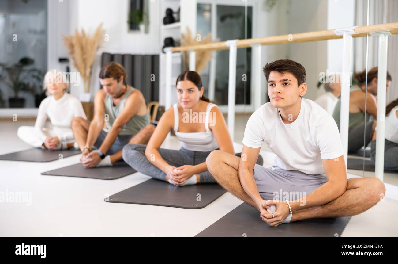 Positive athletic male performing set of exercises on a pilates mat ...