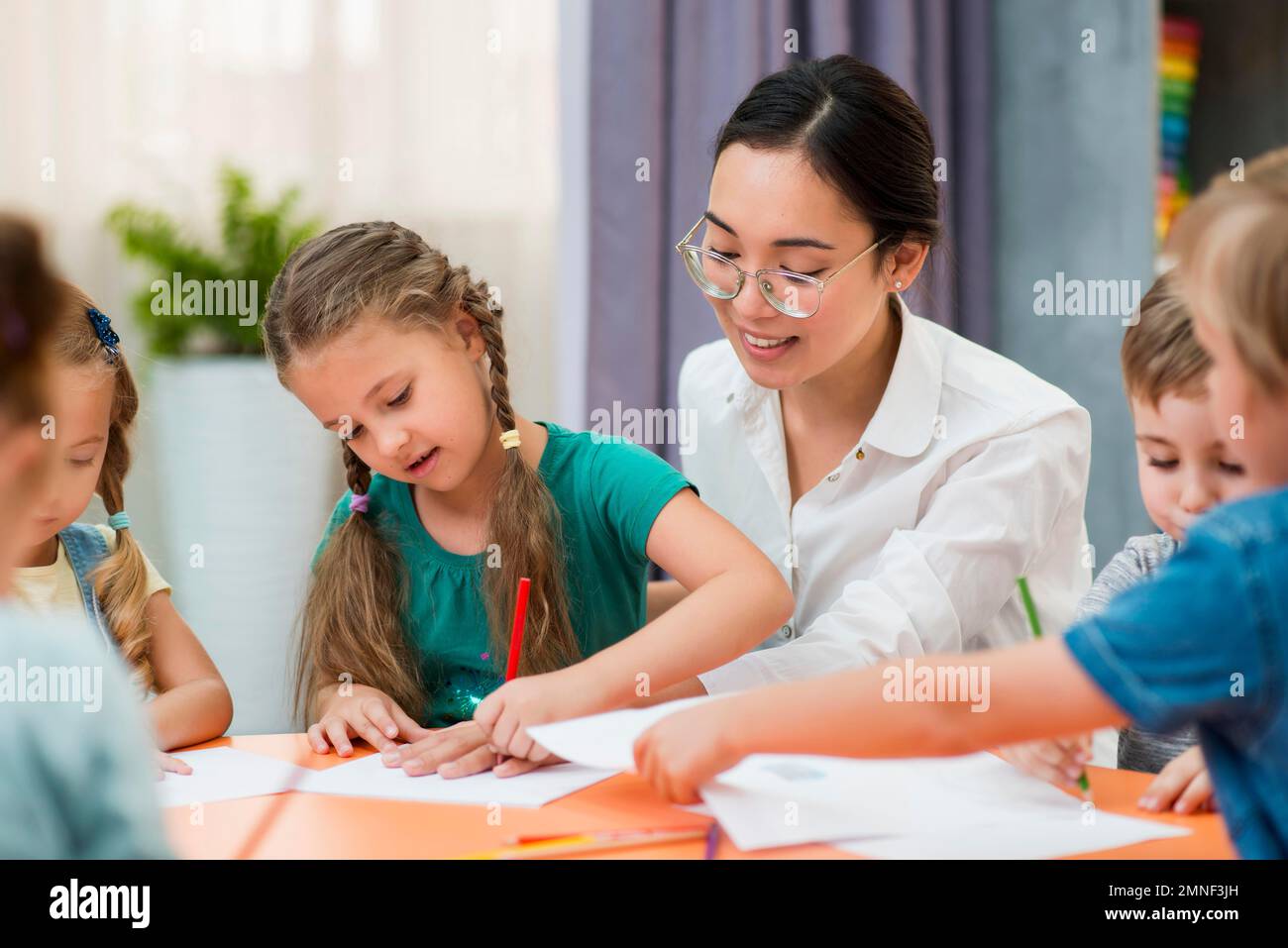 young teacher helping her students class. High resolution photo Stock ...