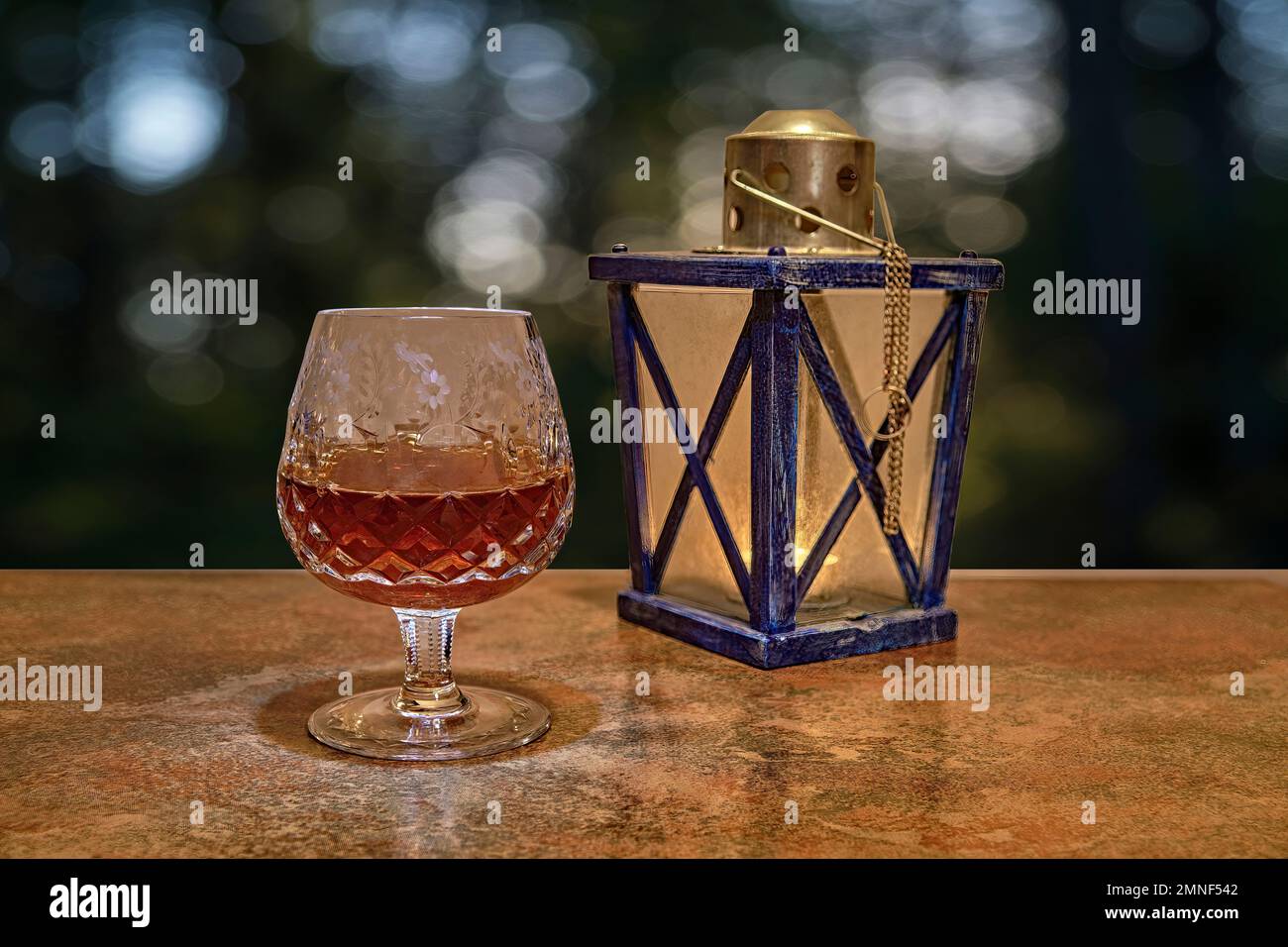 A beautiful cut crystal Brandy Snifter. On a brown marble table and a ...