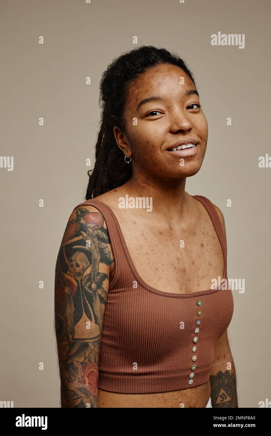 Vertical portrait of young black woman looking at camera standing ...