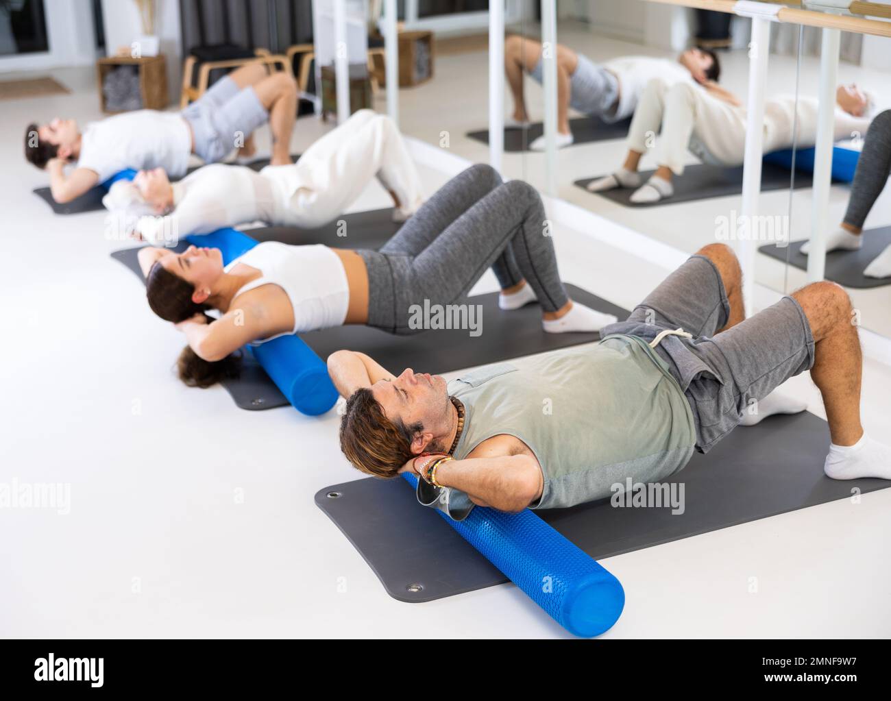 Group of different people doing exercises with roller Stock Photo - Alamy
