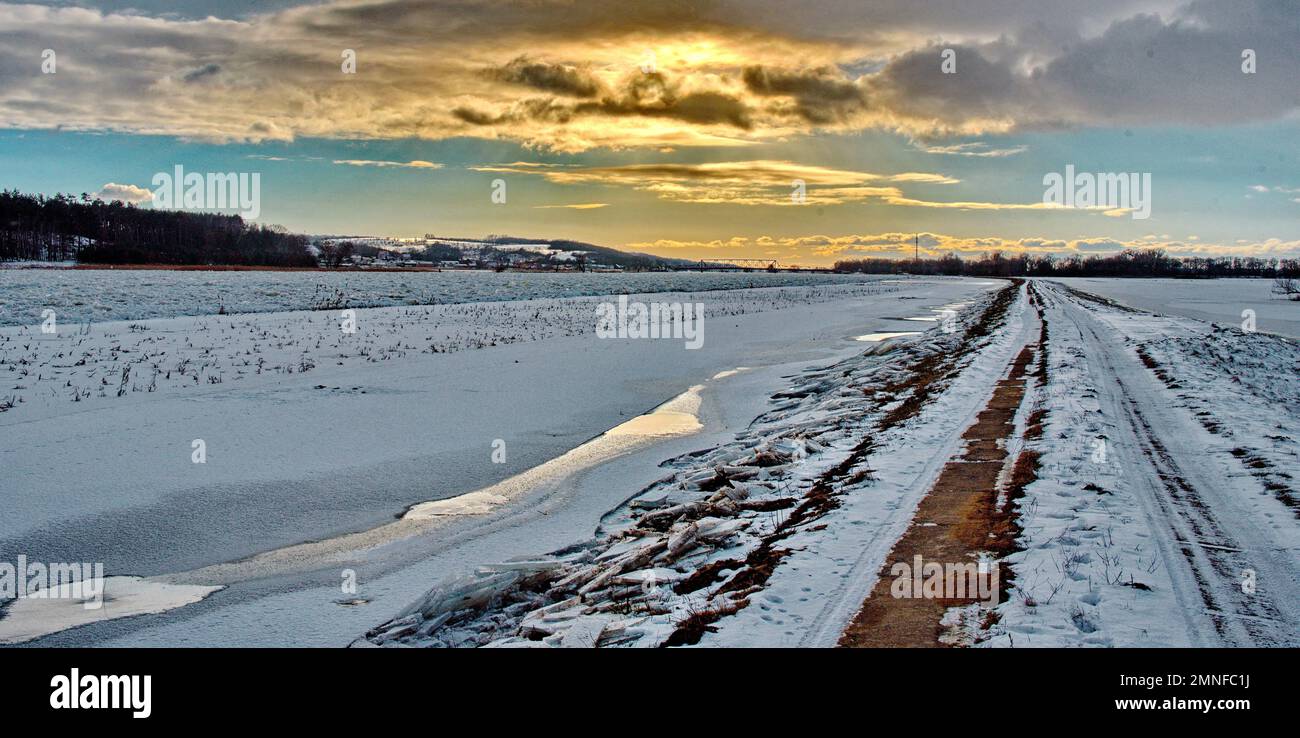 Field path with snow and sun behind clouds, Lower Oder Valley National ...