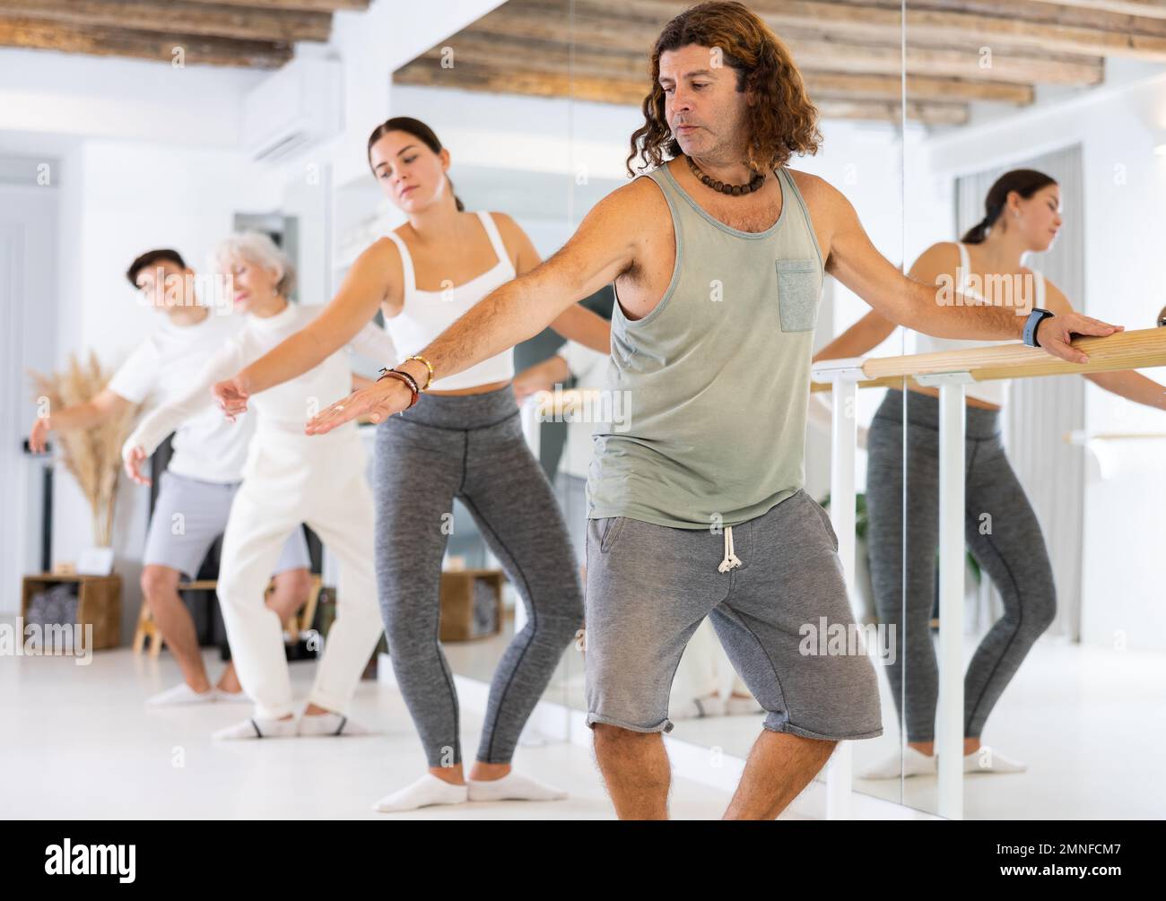 Group of different people doing ballet at barre Stock Photo - Alamy