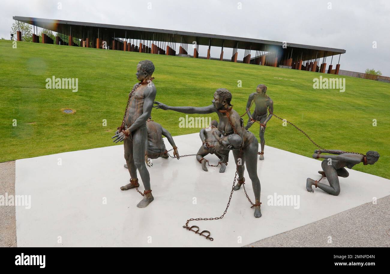 A statue of chained people is on display at the National Memorial for ...