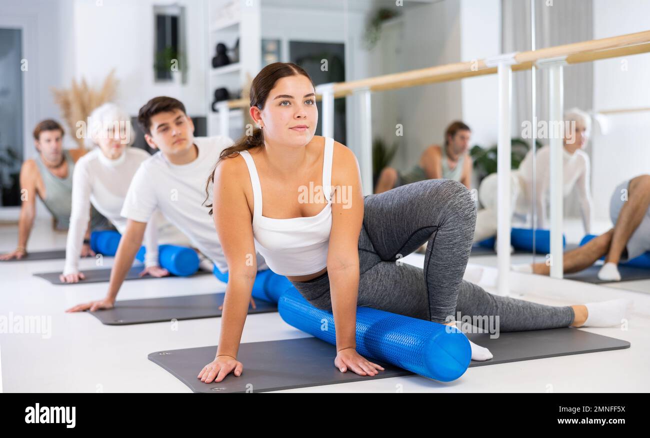 Group of different people doing exercises with roller Stock Photo - Alamy