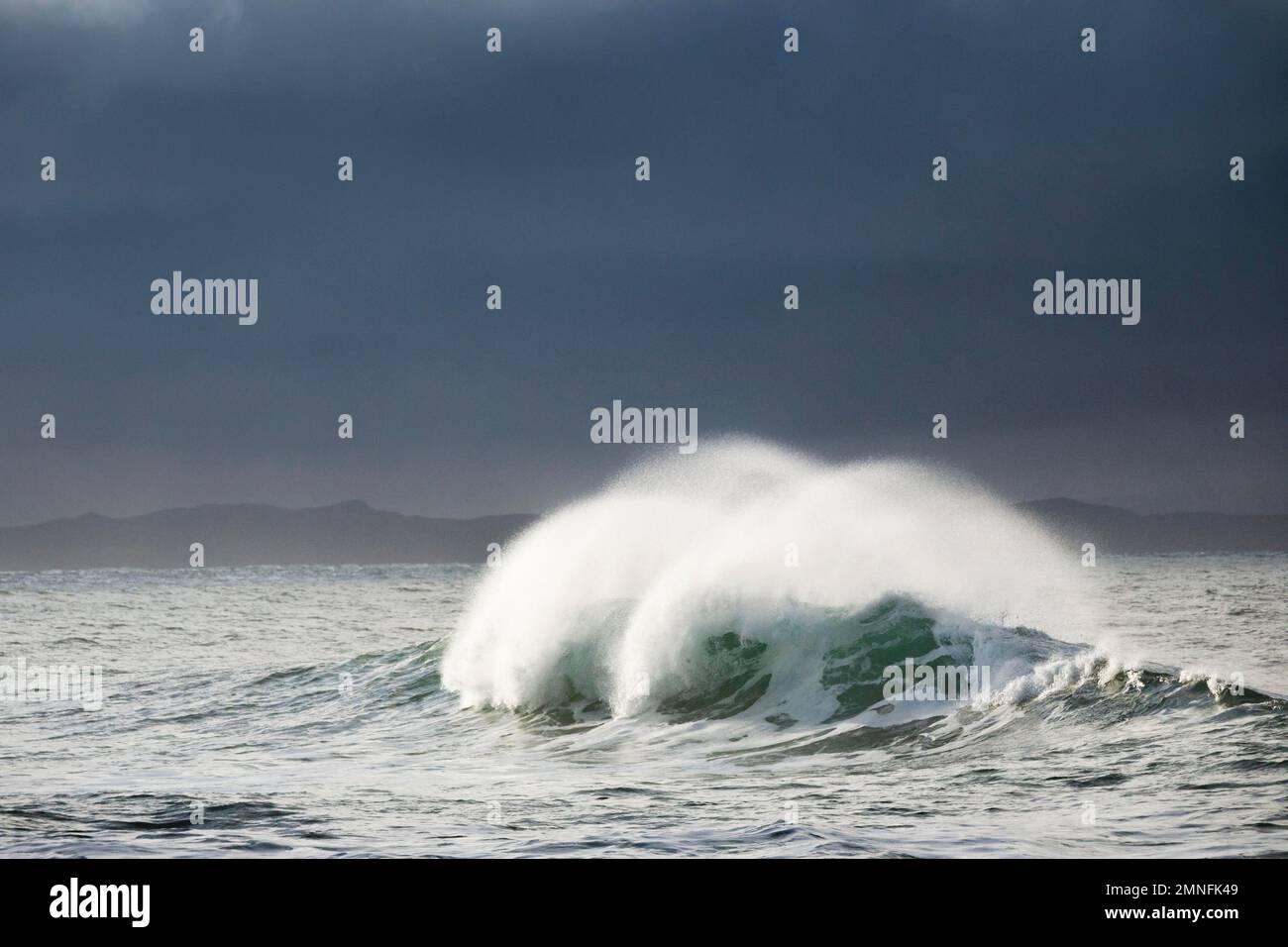 Big wave breaks in winter storm in open sea and dramatic light off ...