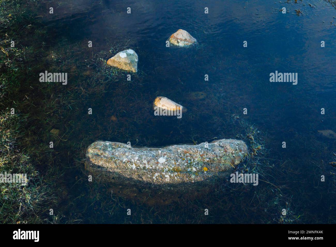 A natural smiley made of stones in the middle of a puddle of water in ...