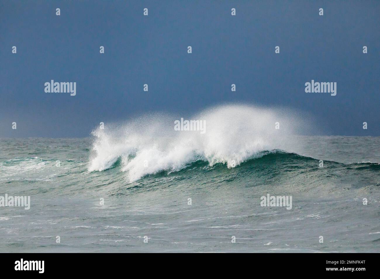 Big wave breaking in the open sea and dramatic light off the north ...