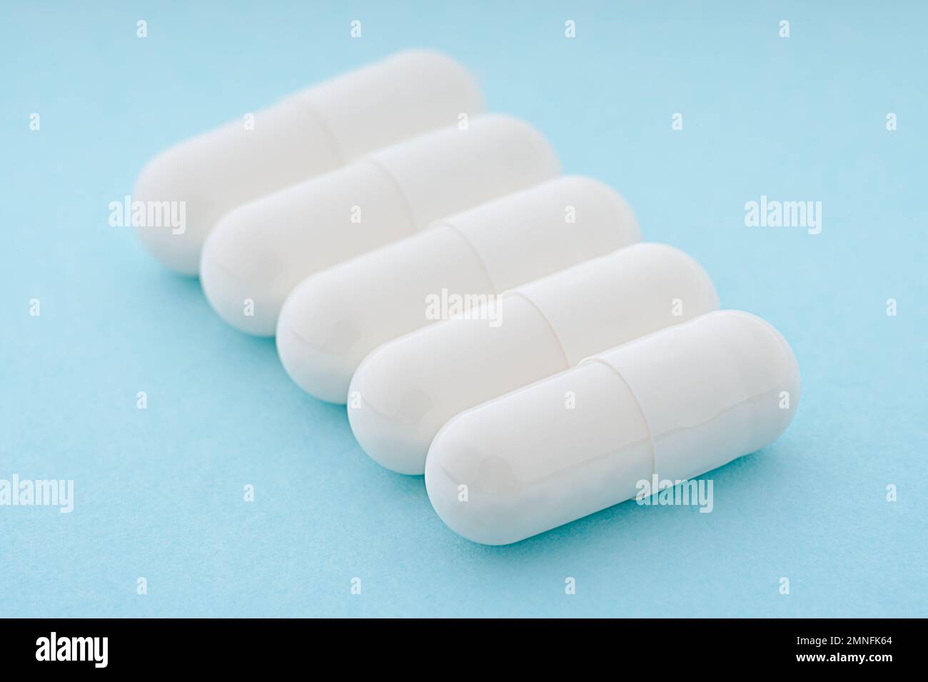 Gel capsule. White medicine capsule on light blue background. food ...