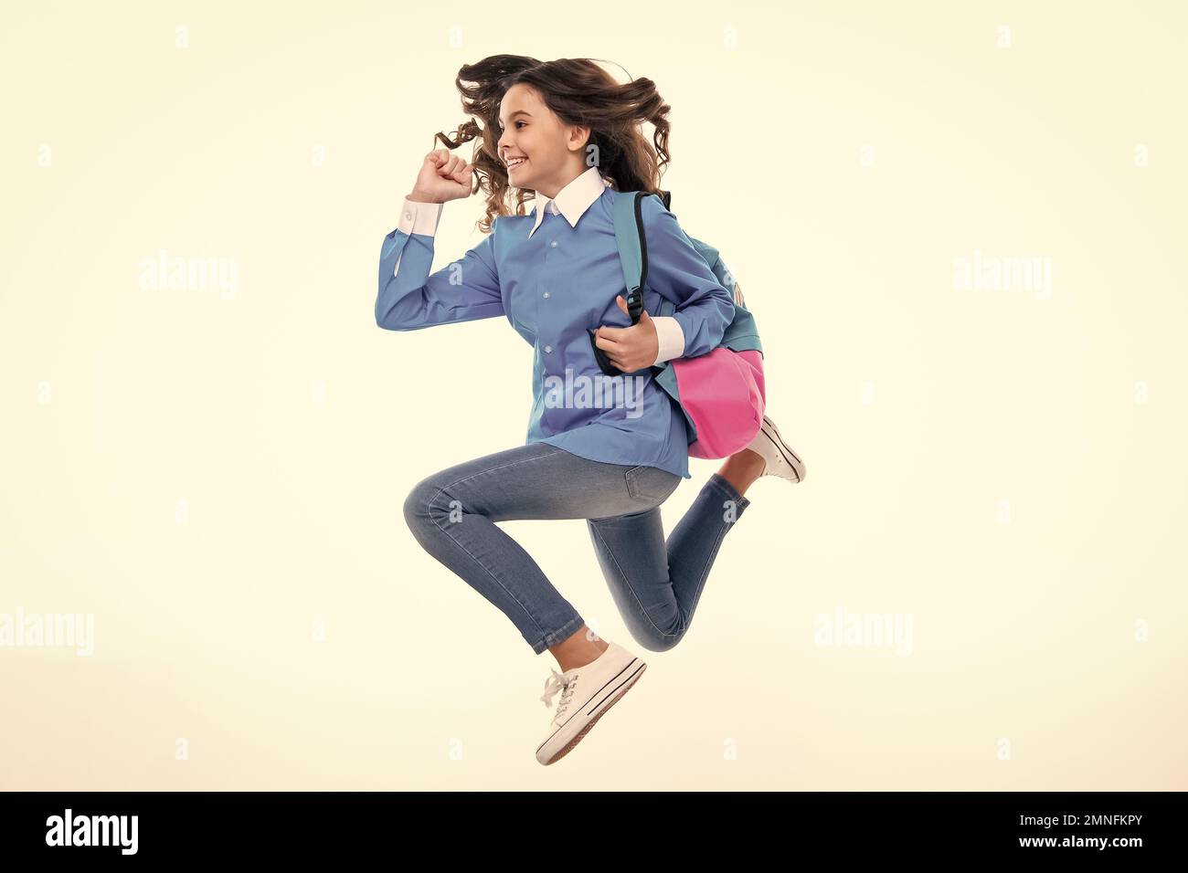 Schoolgirl in school uniform with school bag. Run and jump. Schoolchild ...