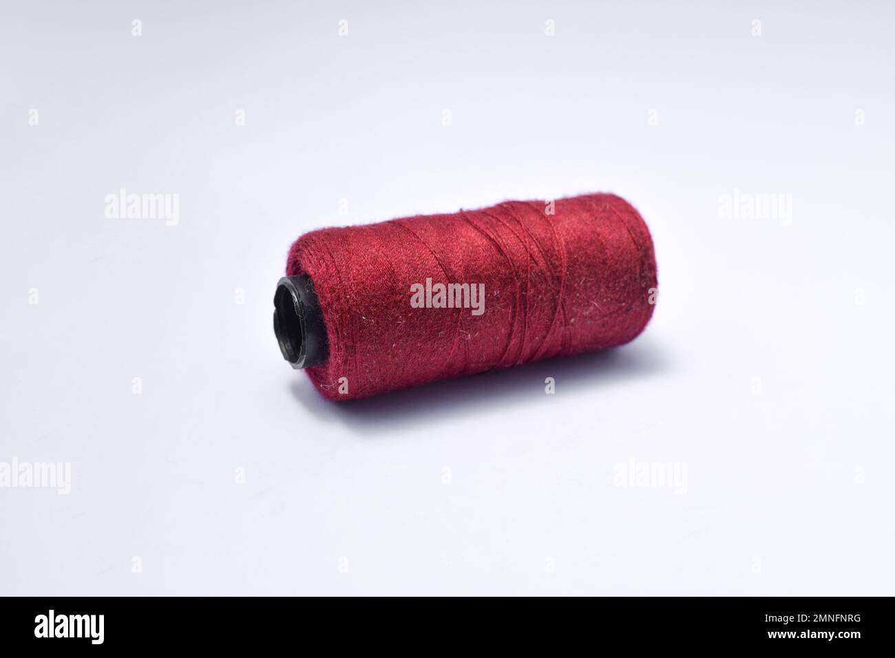 Red spool of thread isolated on white background Stock Photo - Alamy