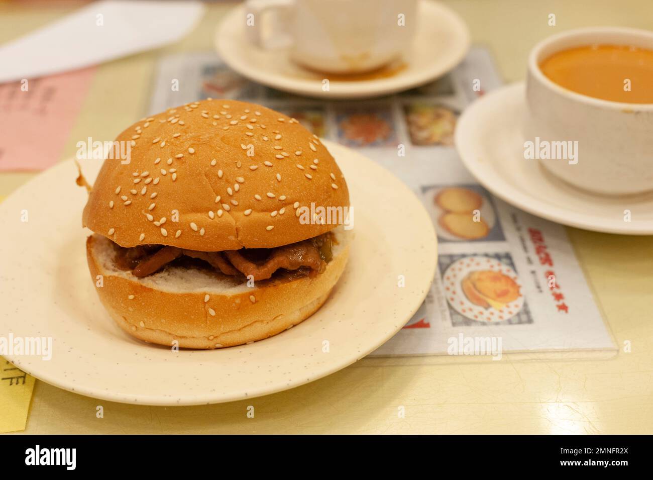 Meat on a bun and hot milk tea served at a traditional Cha chaan teng ...