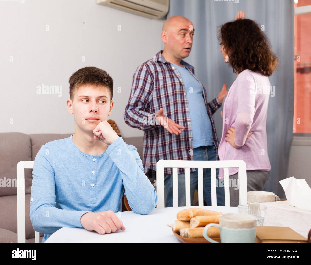 Unhappy teen boy with quarreling parents Stock Photo - Alamy
