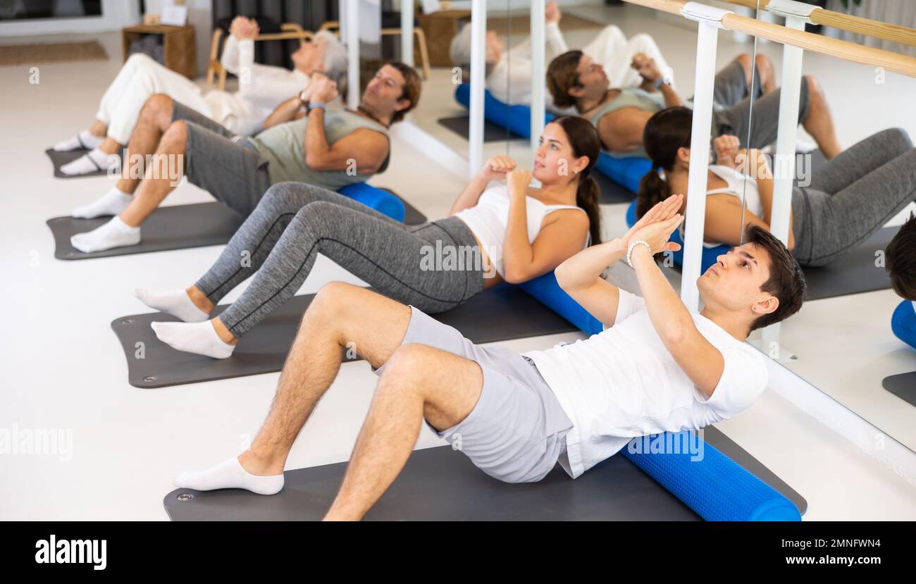 Group of different people doing exercises with roller Stock Photo - Alamy