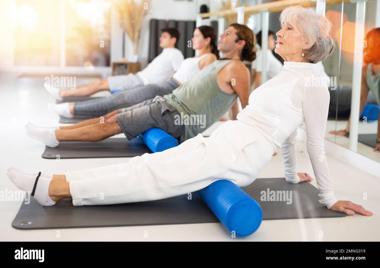 Elderly woman doing pilates with roller Stock Photo - Alamy
