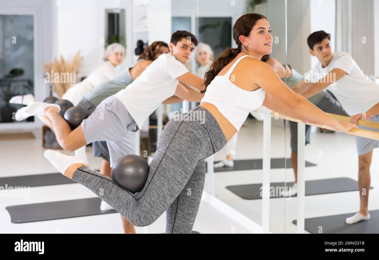 Group of different people doing exercises at barre Stock Photo - Alamy