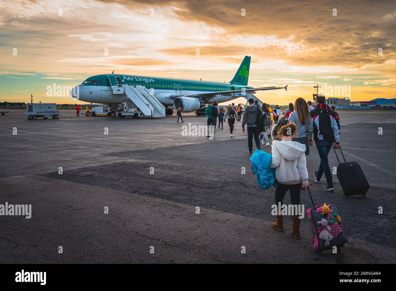 Perpignan, France, Jan People going to airplane parked on airport runway. Tourists boarding Aer ...
