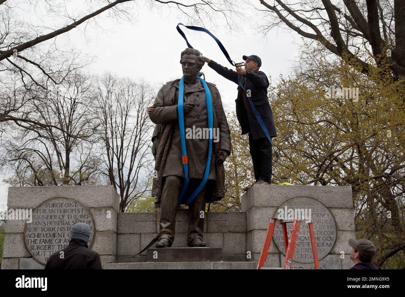 A worker tosses a strap over the 19th century statue of Dr. J. Marion ...