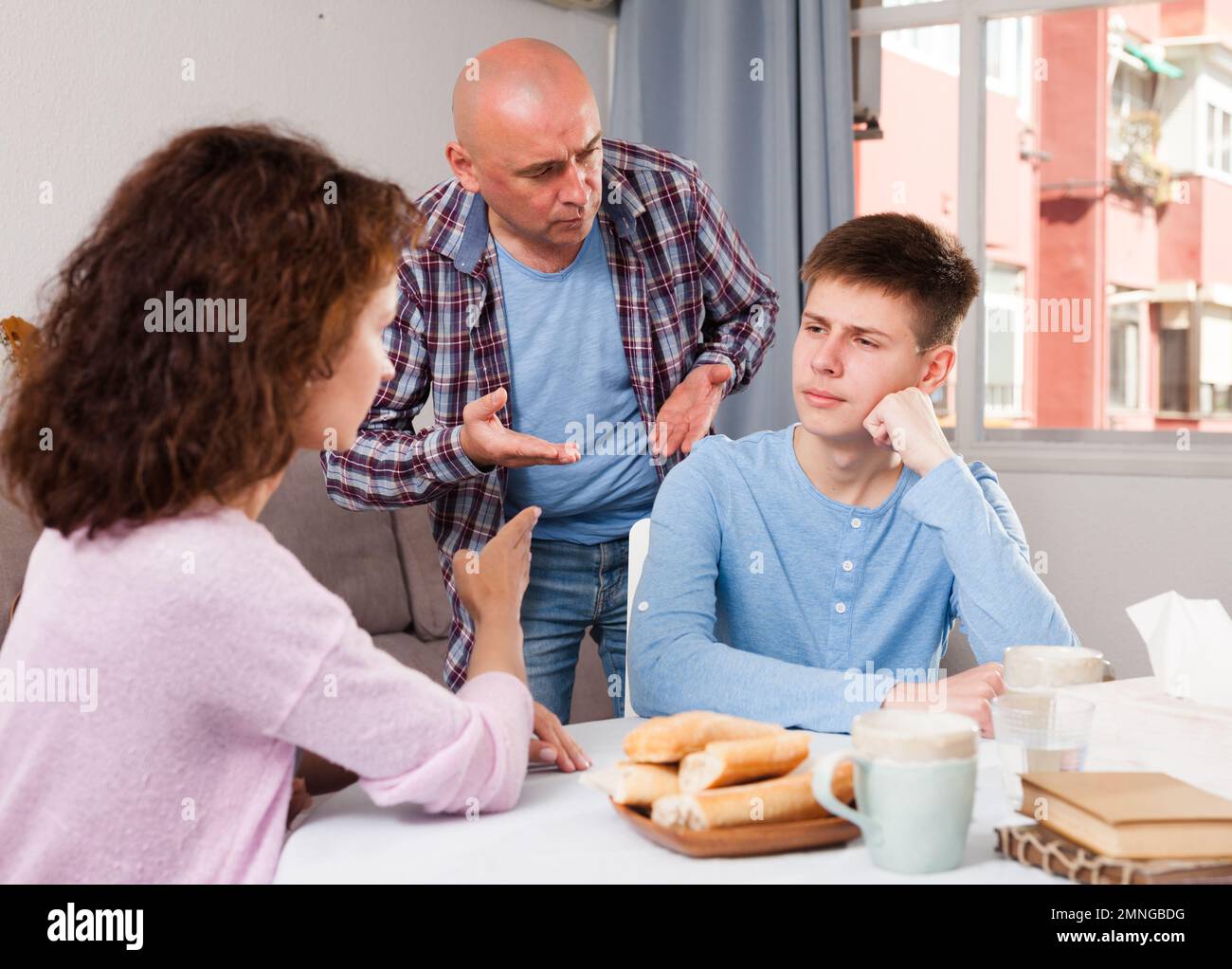 Teenager listening to reprimanding parents Stock Photo - Alamy