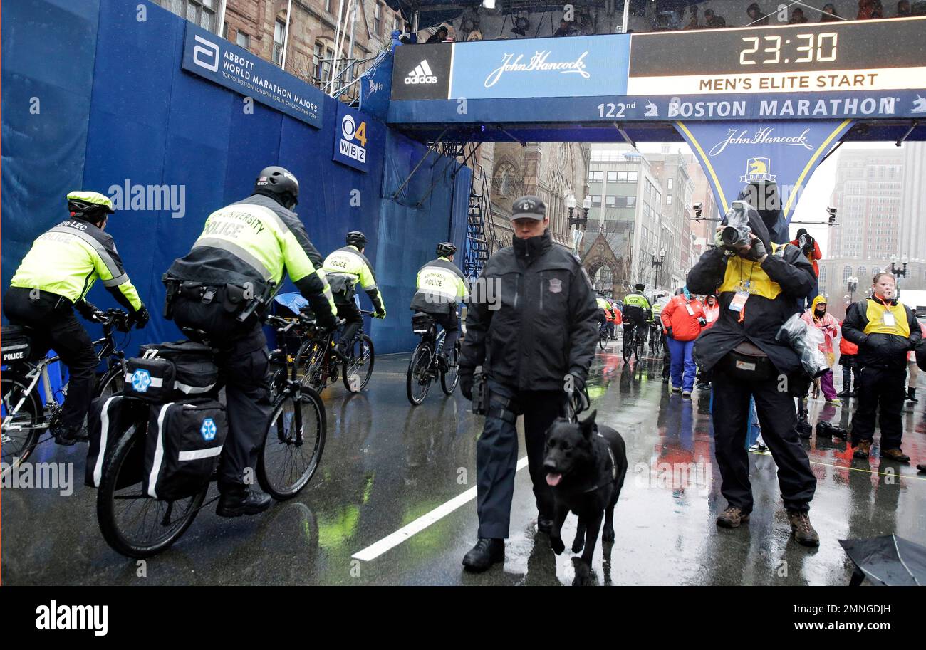 Bicycle-mounted police officers pass a Boston Special Operations K-9 ...