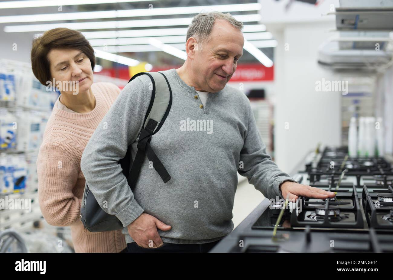 Middle aged wife and husband picking new gas stove in store Stock Photo ...