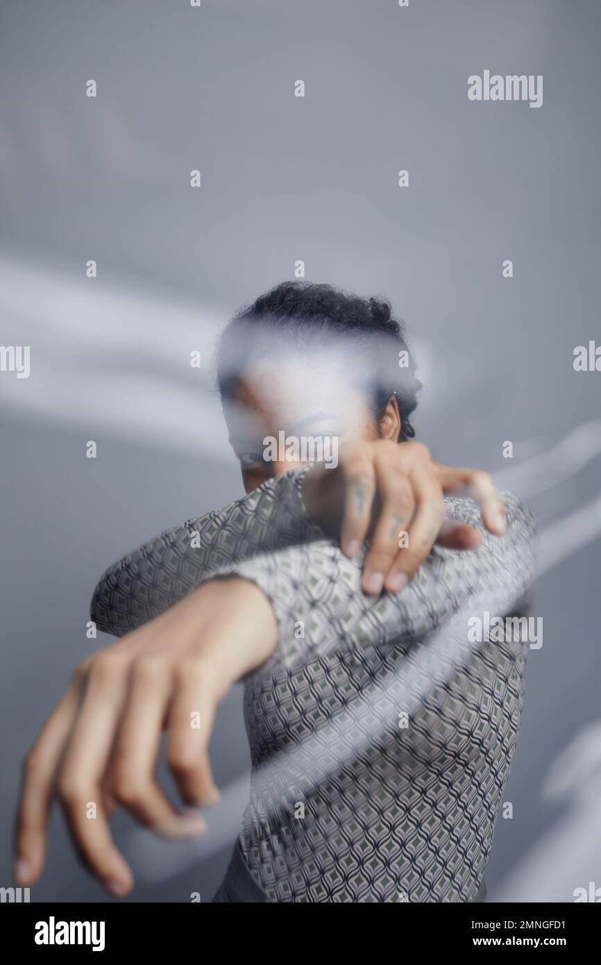 Minimal portrait of young black woman dancing and moving in hazy studio ...