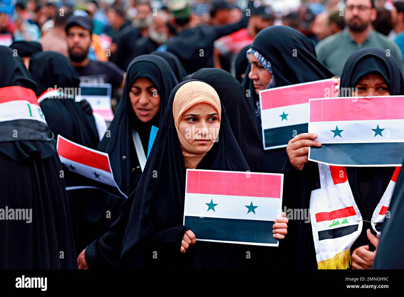 Women hold Syrian flags during a protest against the U.S.-led missile ...