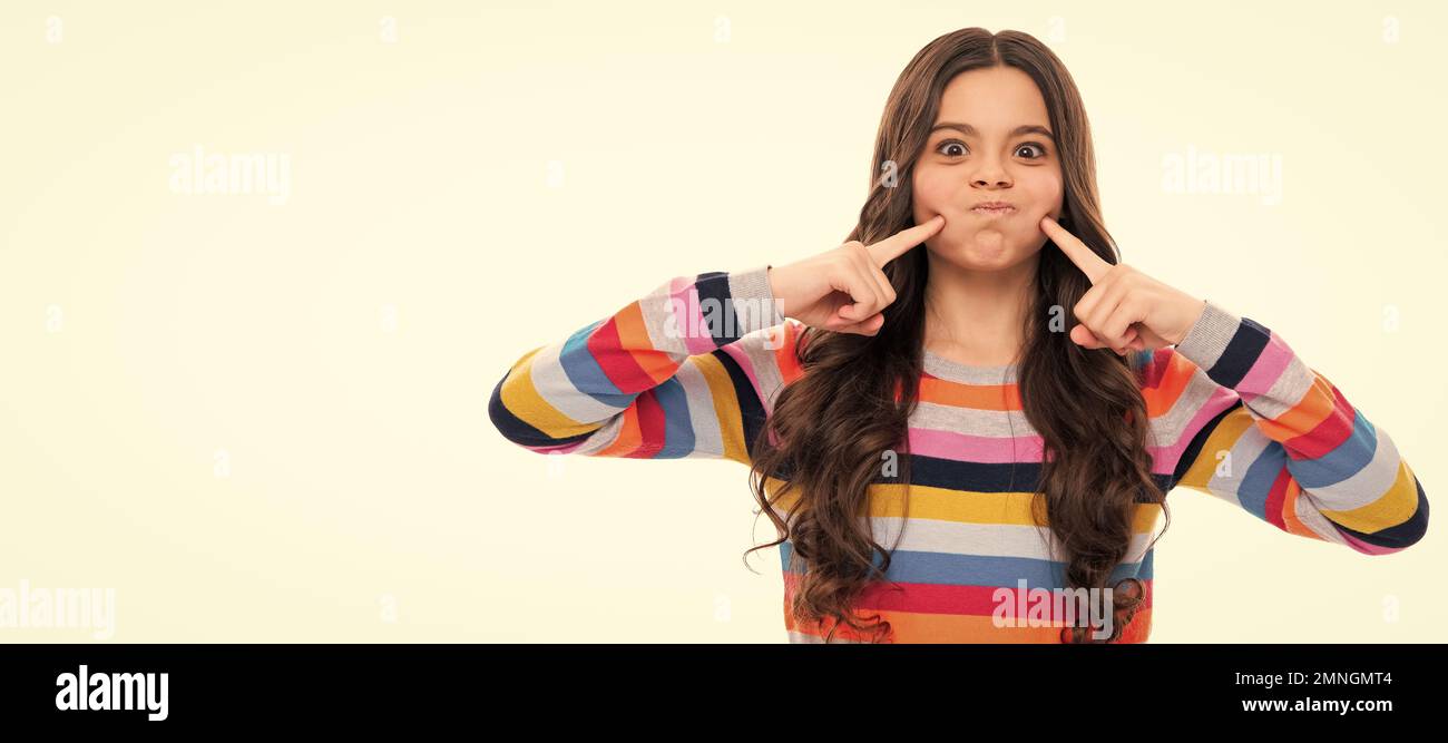 Funny face. Beautiful teen child pinching cheeks with index finger ...