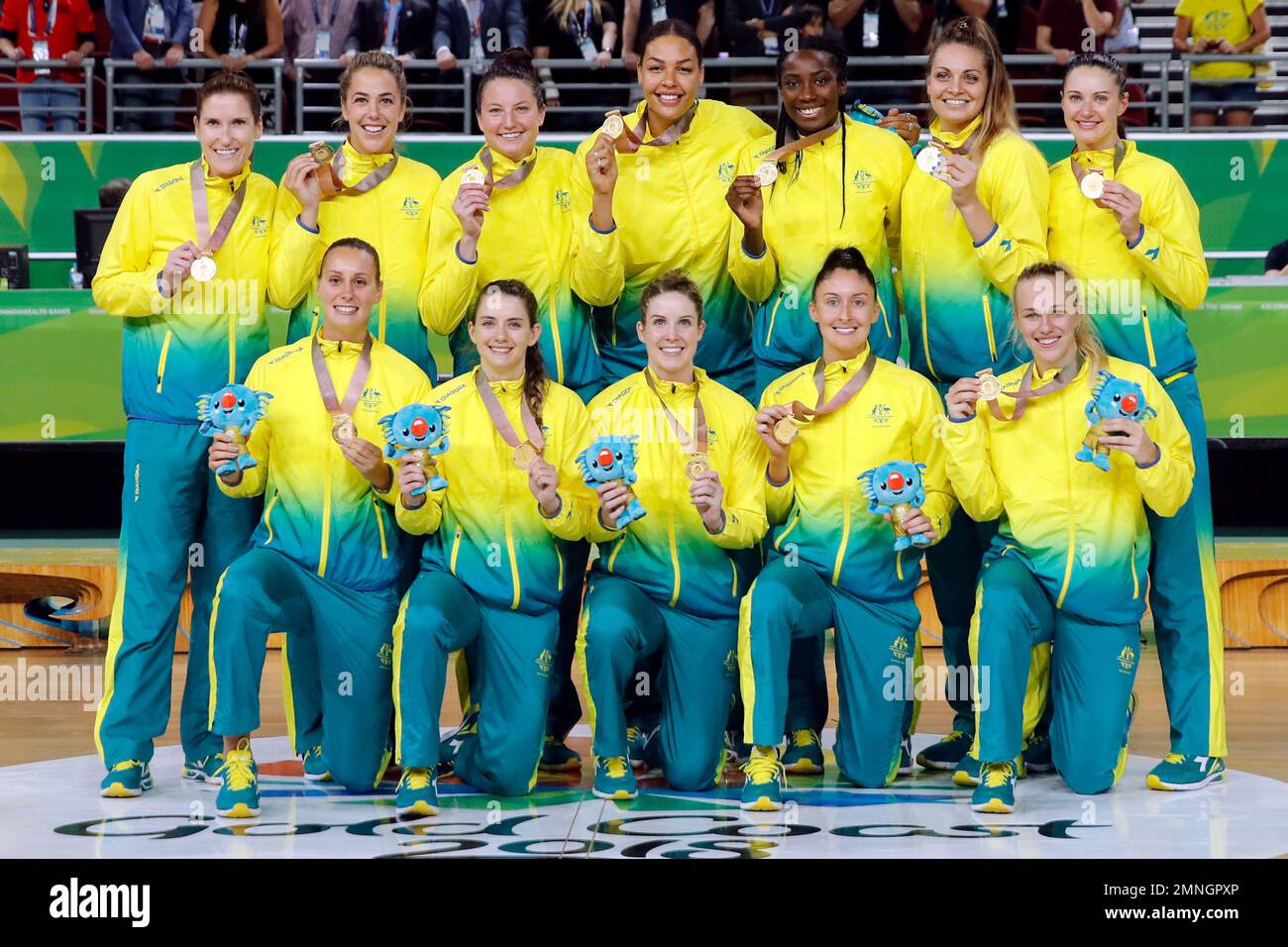 Members of Australia's women's basketball team stand with their gold ...
