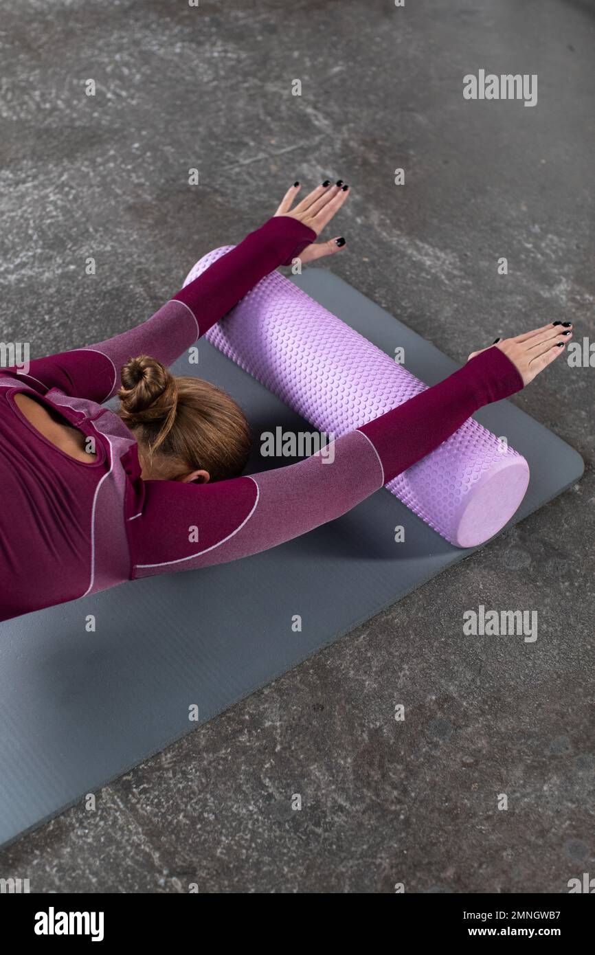 A fitness instructor demonstrates a myofascial massage of the forearm ...