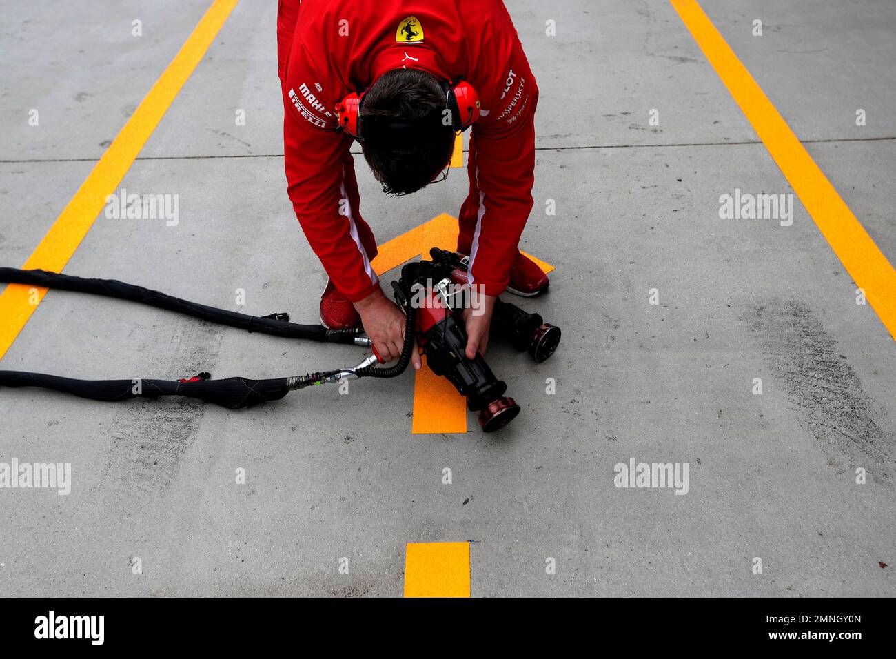 A Ferrari crew member testing the wheel guns during the first practice ...