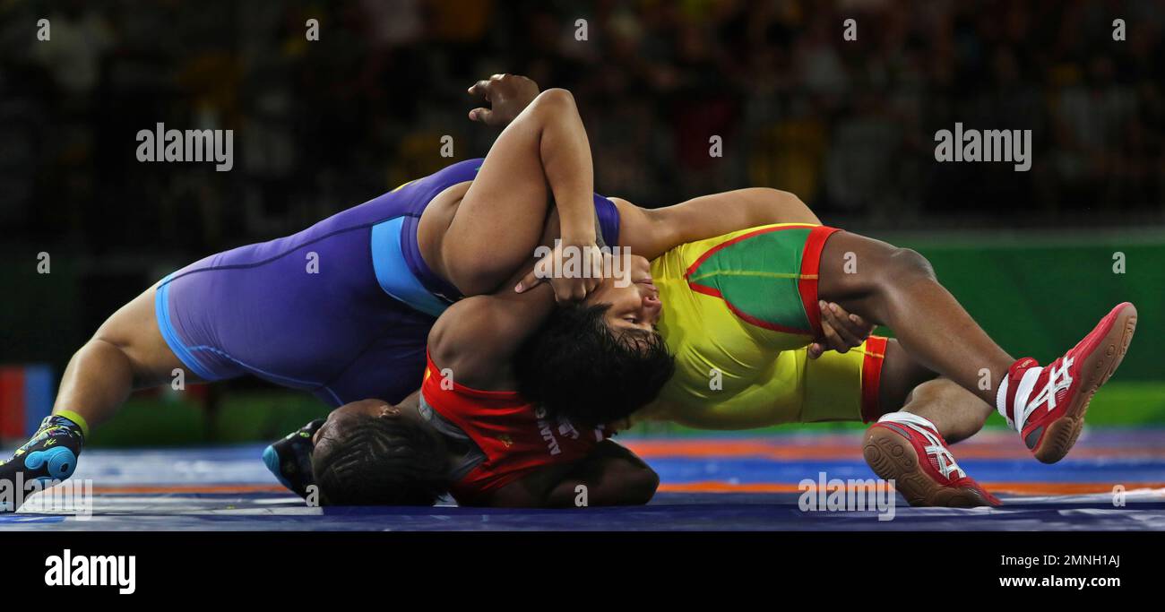 India's Divya Kakran, in blue, wrestles with Cameroon's Gaella Anzong ...