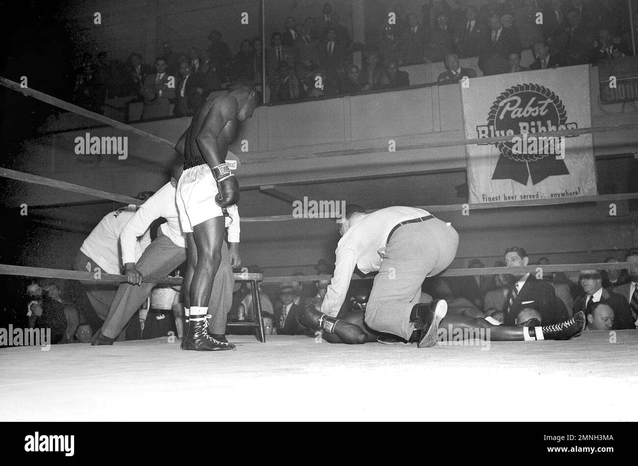 Referee Harry Ebbetts bends over Sonny Boy West of Washington, D.C ...