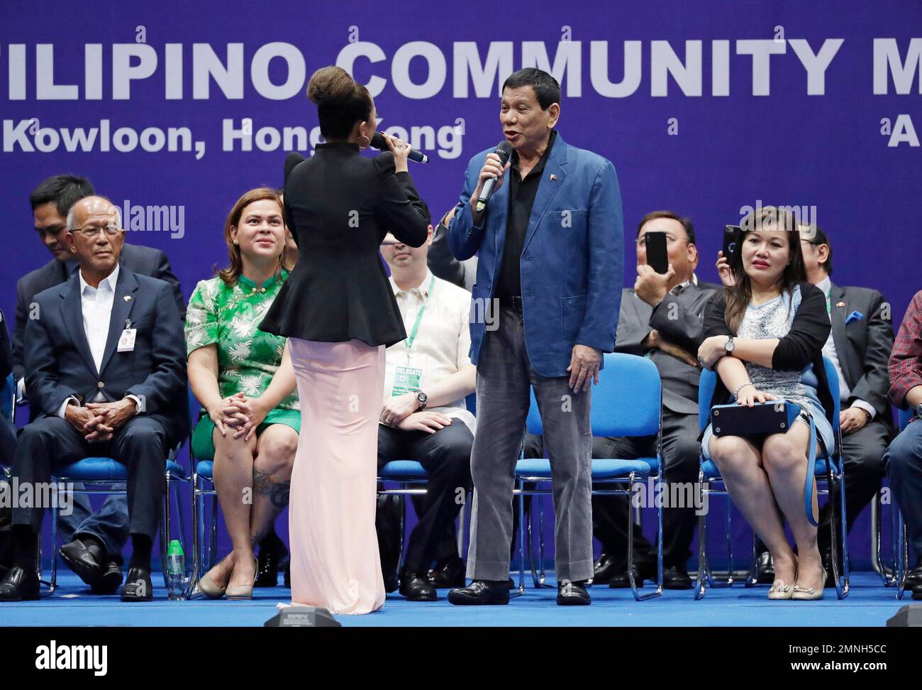 Philippine President Rodrigo Duterte sings with a performer as he ...