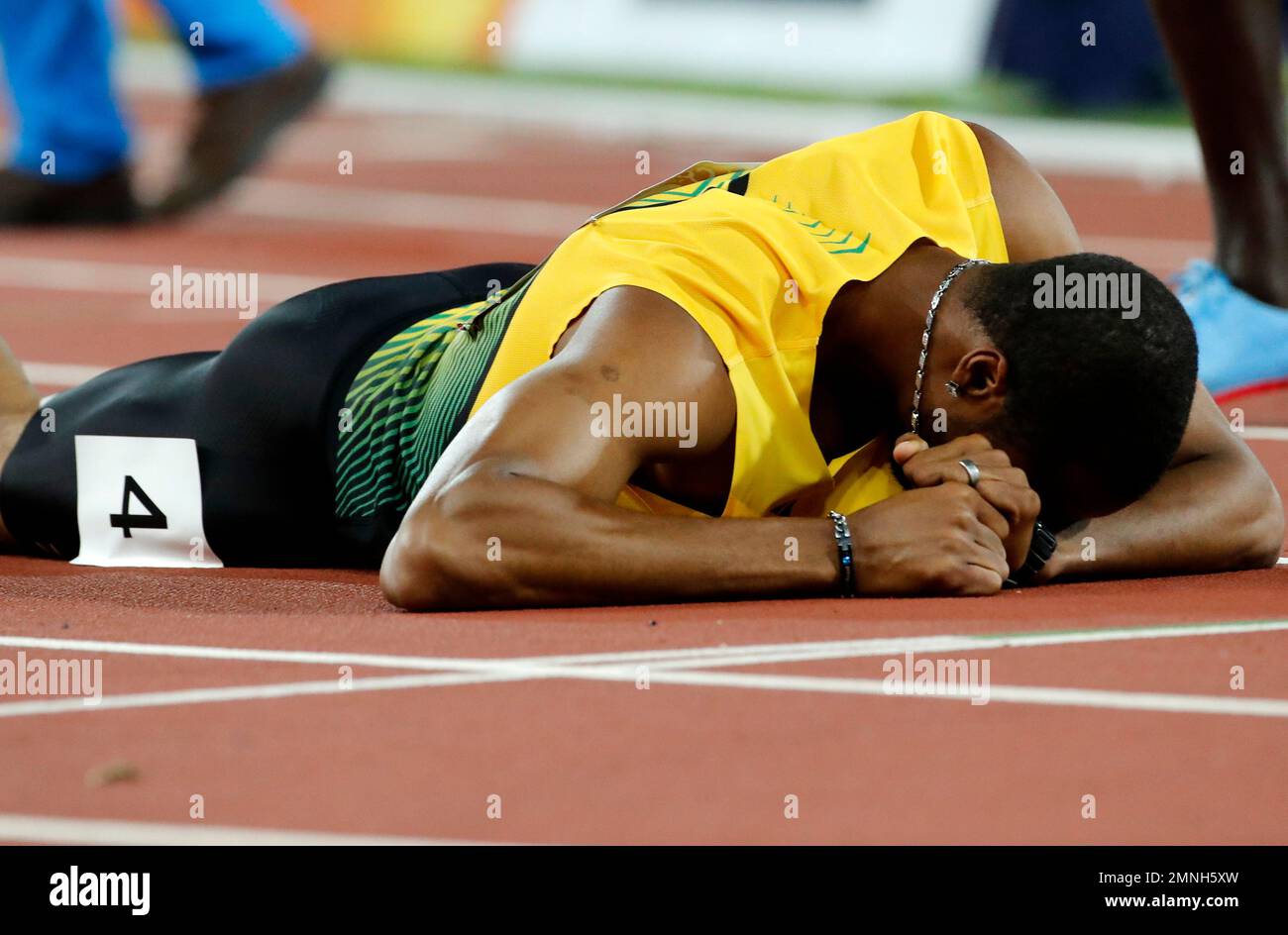 Jamaica's Andre Clarke lies on the track after his run in the men's ...