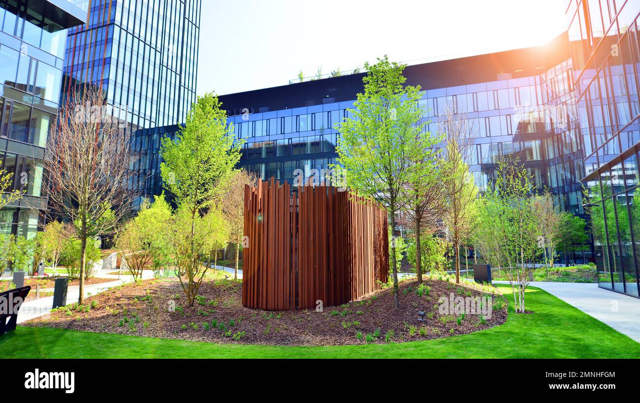 Eco architecture. Green tree and glass office building. The harmony of ...