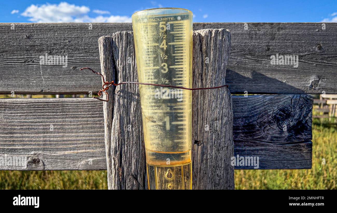 A rain gauge on a fence post at a New Mexico ranch shows an overnight ...