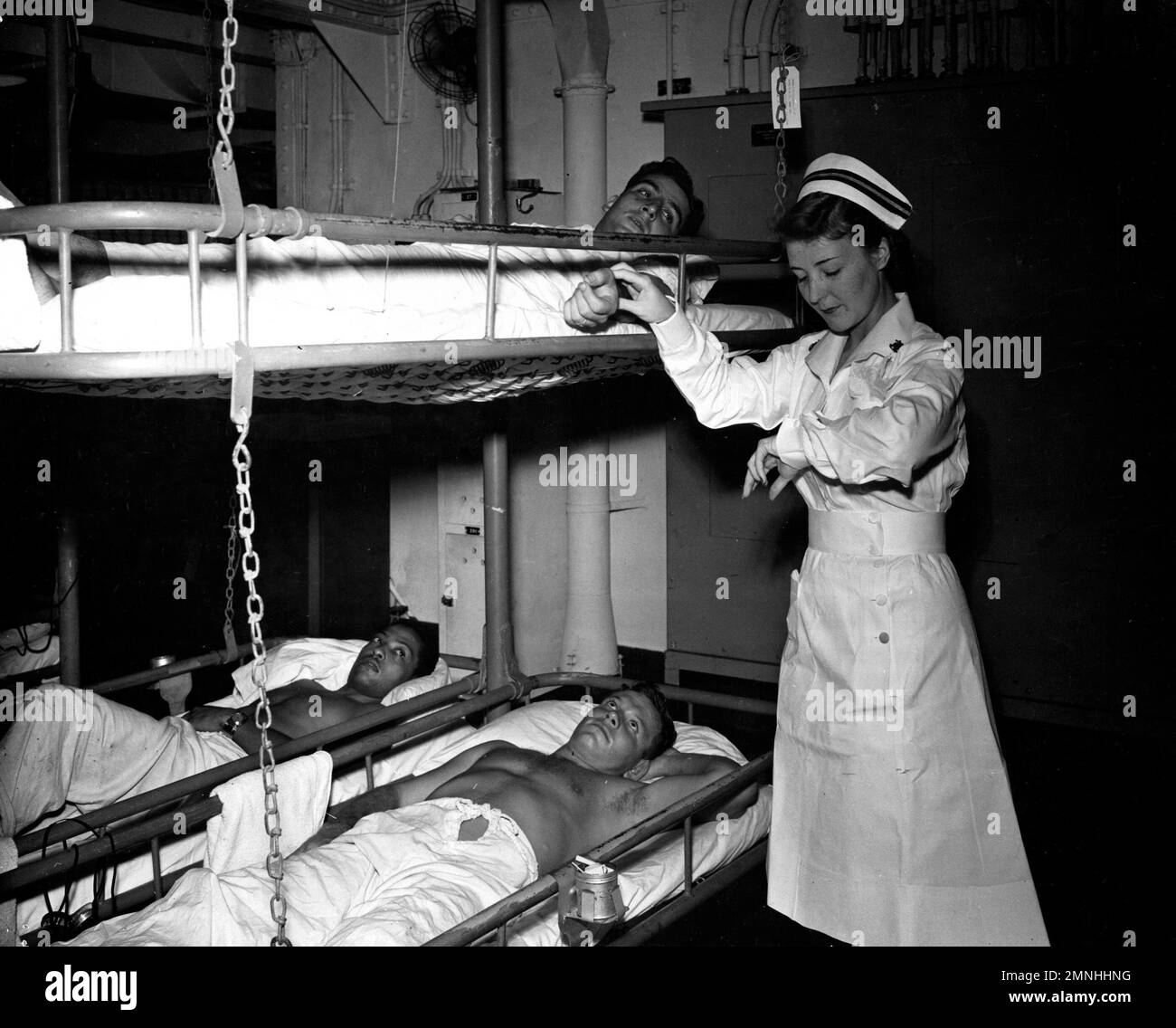 USS Bountiful (AH-9) hospital ship. A nurse takes the pulse of a man in ...