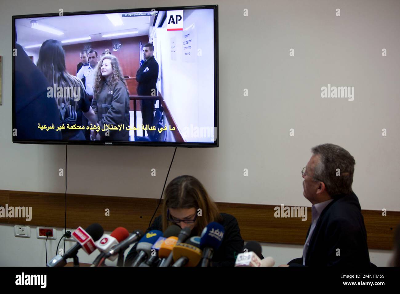 Palestinian Bassem Tamimi, right, looks at a video that shows his ...