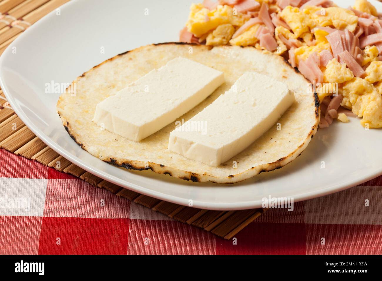 Arepa for breakfast, cheese and scrambled egg, a traditional Colombian ...