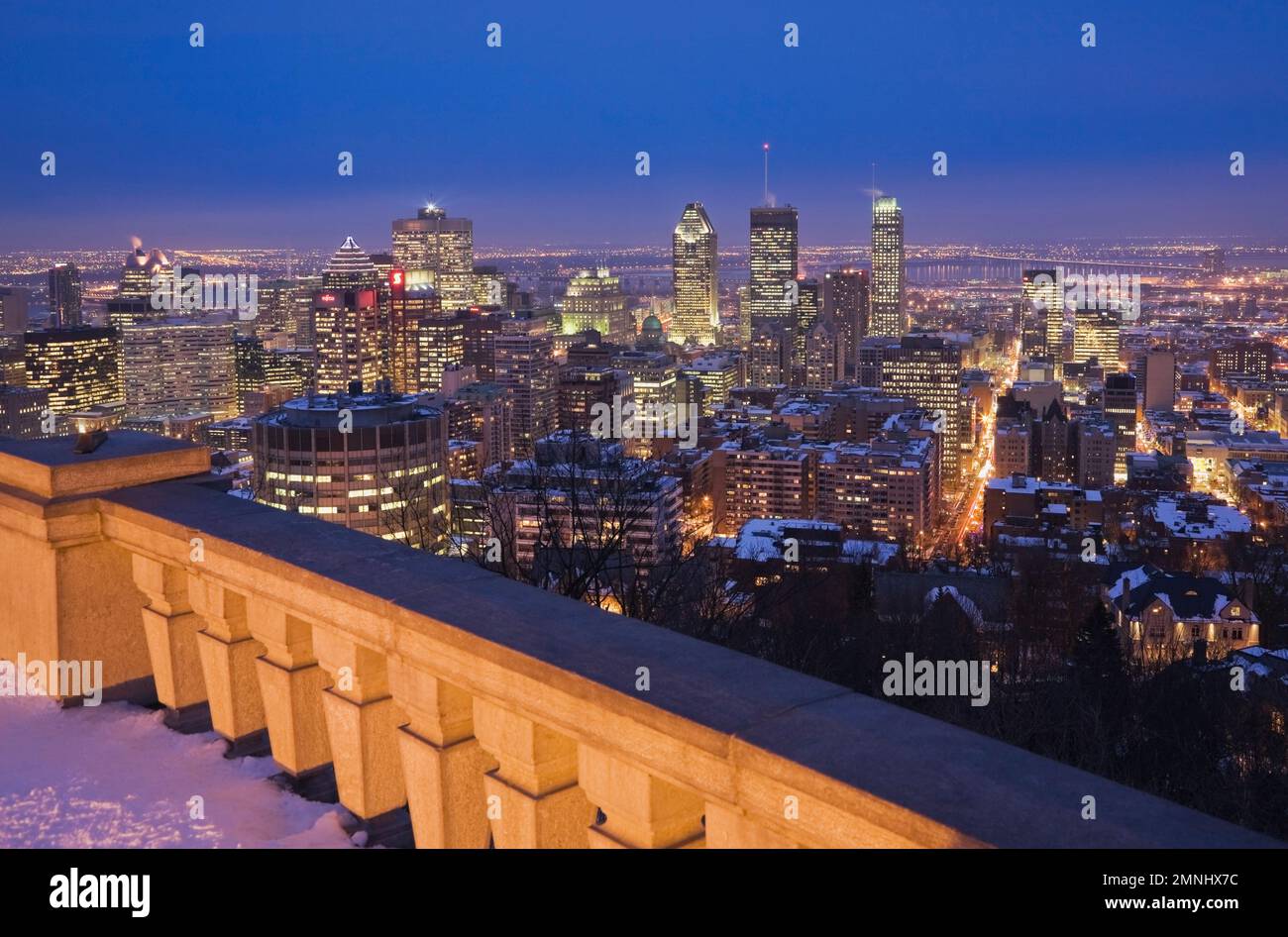 Cement railing and Montreal skyline illuminated at dusk in winter taken ...