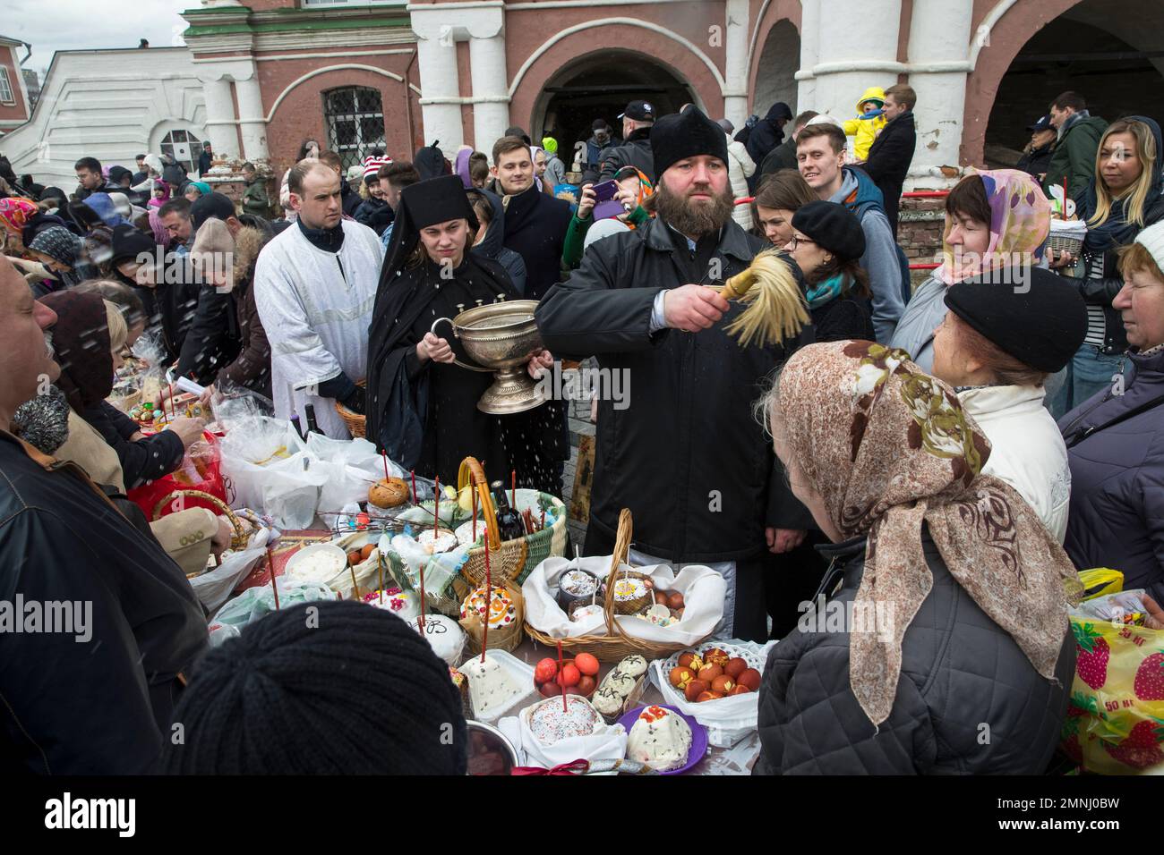 A Russian Orthodox priest blesses people as they hold traditional ...