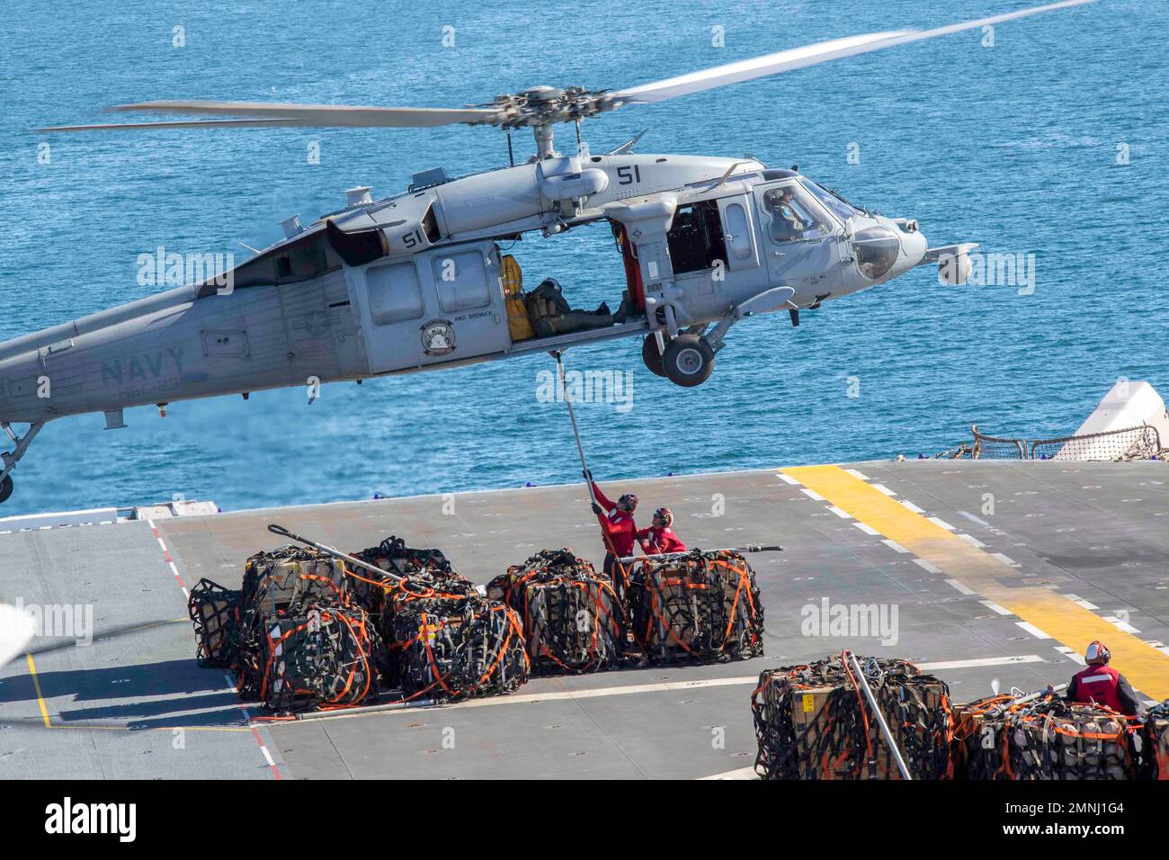 Pacific Ocean. 25th Jan, 2023. Sailors attach a pallet of ammunition to ...