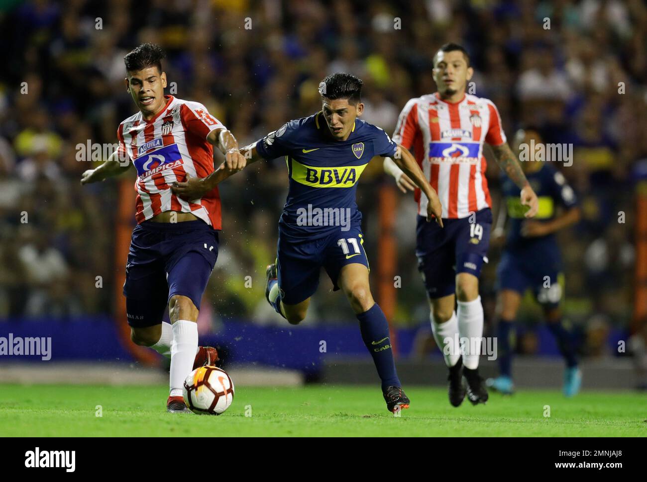 Jorge Arias of Colombia's Junior, left, fights for the ball with ...
