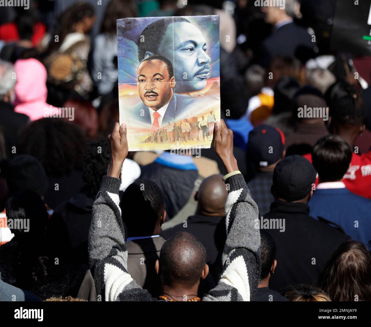 A man holds a poster of Rev. Martin Luther King Jr. as he attends ...