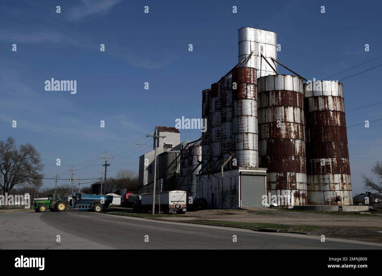 A tractor pulling a load of corn pulls away from a Perry Milling grain ...