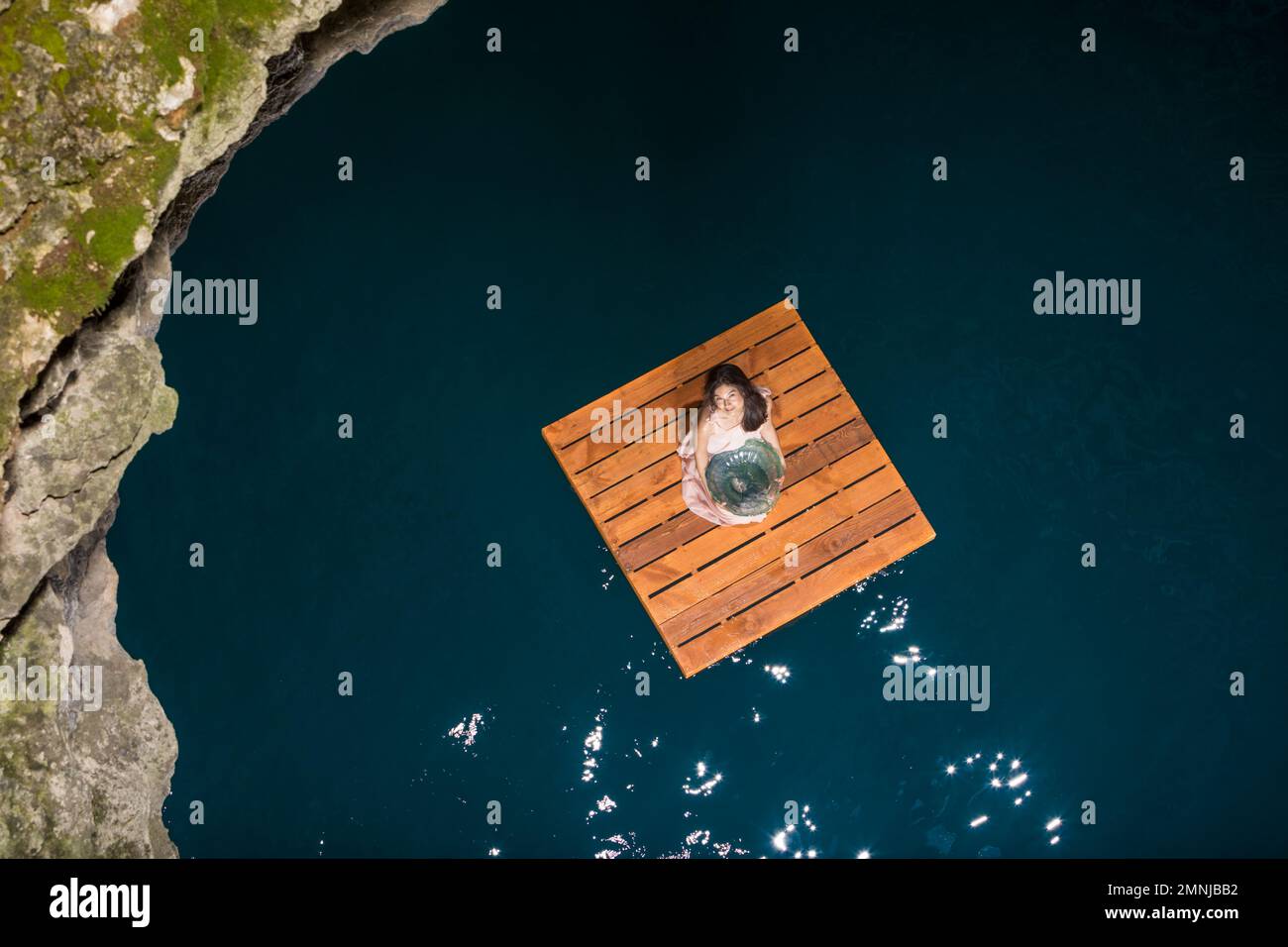 Aerial view of woman sitting on wooden raft Stock Photo - Alamy