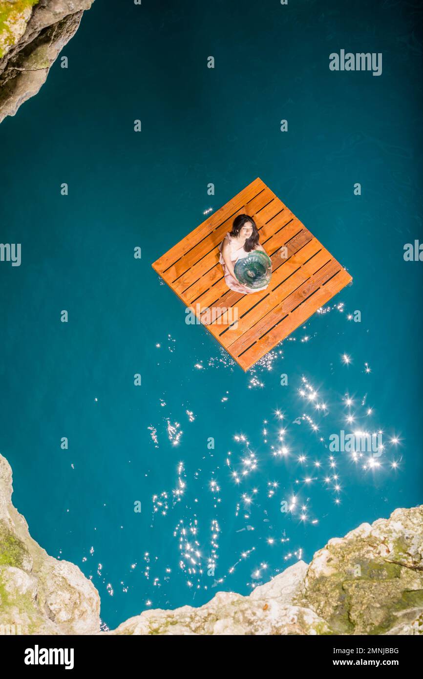 Aerial view of woman sitting on wooden raft Stock Photo - Alamy